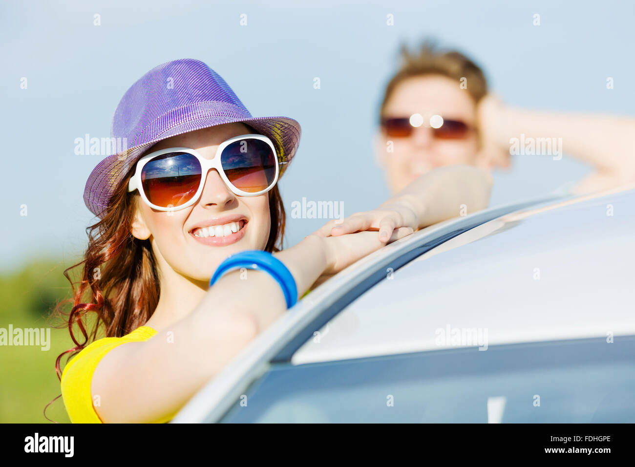 Young people sitting near car aside of road Stock Photo - Alamy