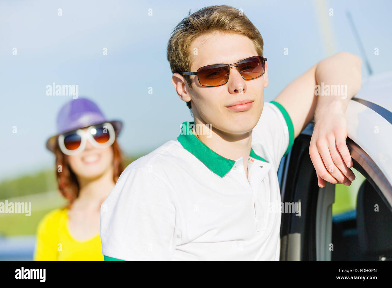 Young people sitting near car aside of road Stock Photo - Alamy
