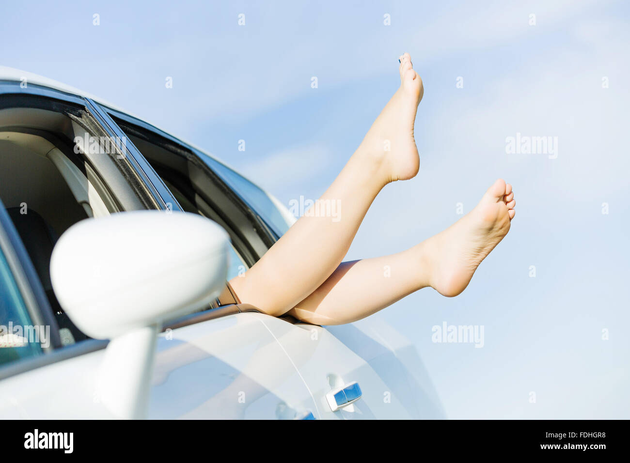 Feet of woman leaned out of car window Stock Photo - Alamy