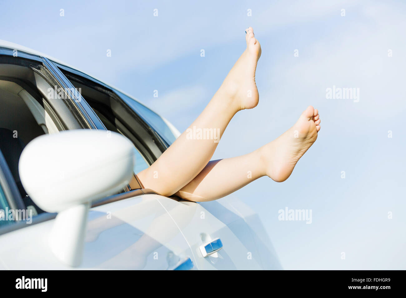Feet of woman leaned out of car window Stock Photo - Alamy