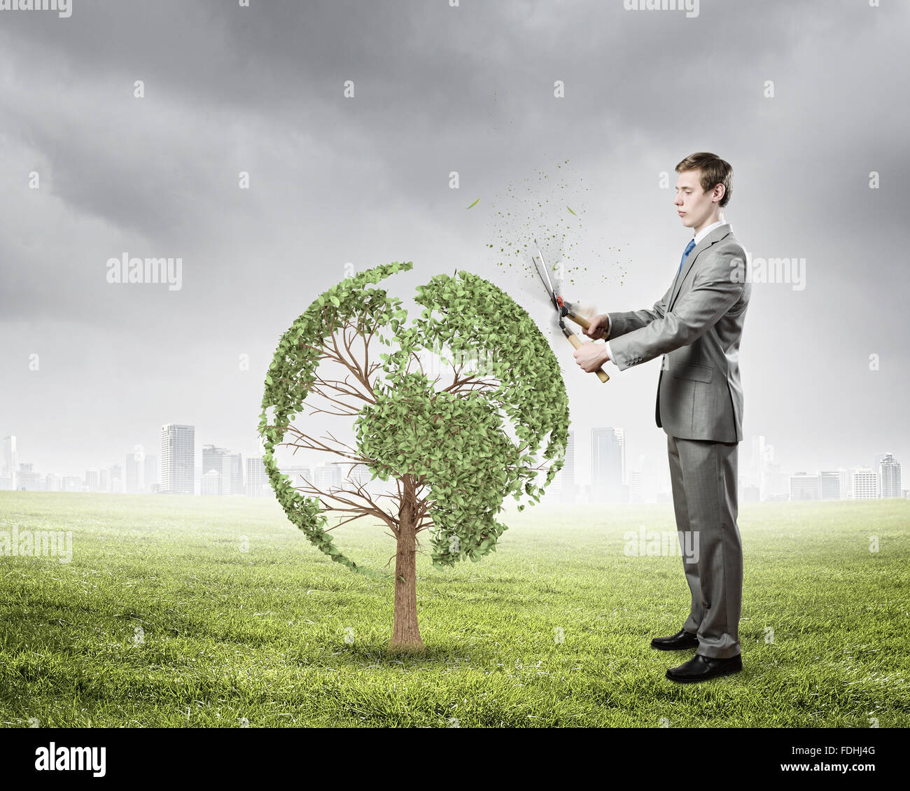 Young businessman cutting tree with scissors in shape of Earth planet ...