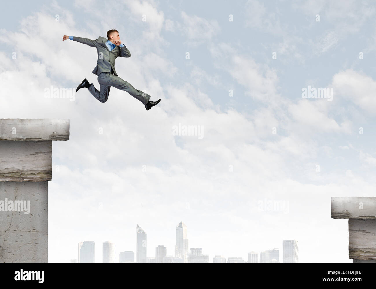 Young successful businessman jumping over gap. Risk and challenge ...