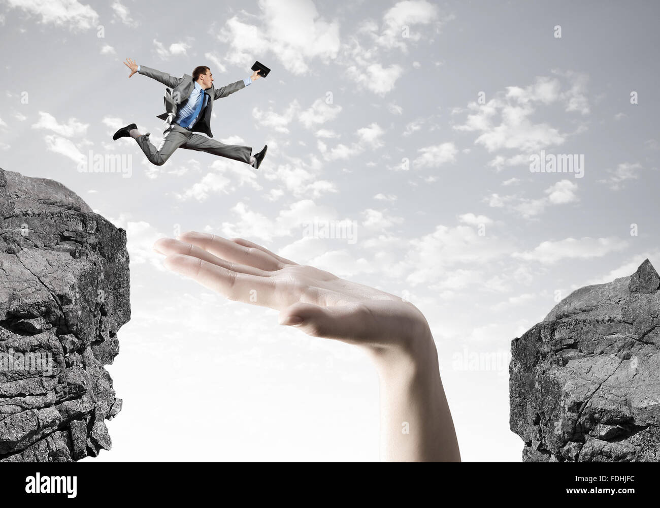 Young successful businessman jumping over gap. Risk and challenge ...