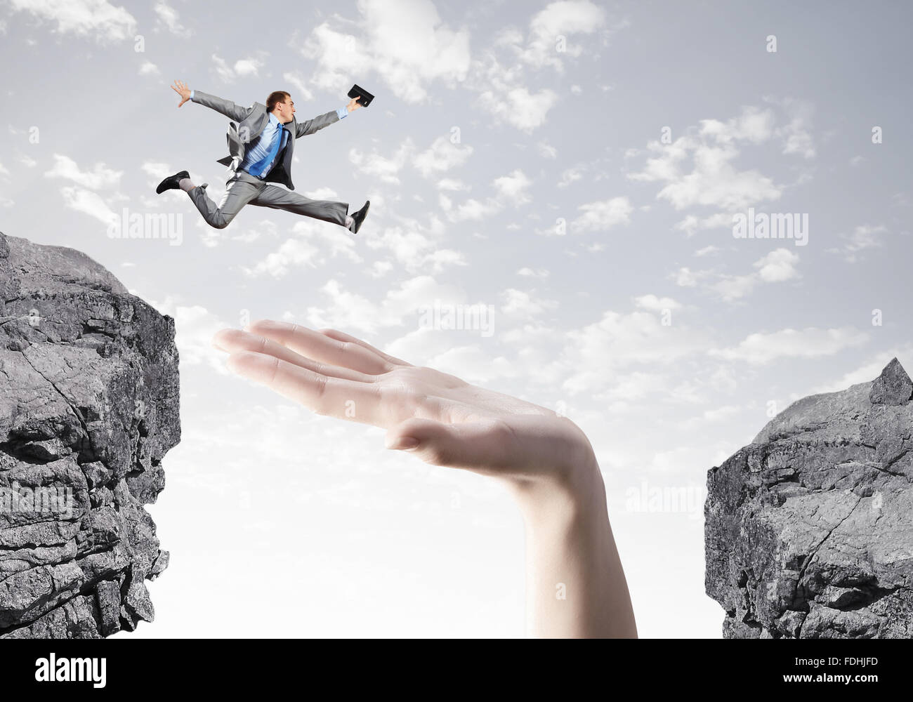 Young successful businessman jumping over gap. Risk and challenge ...