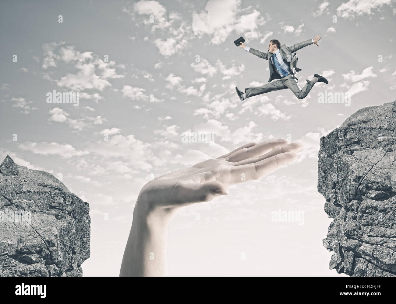 Young successful businessman jumping over gap. Risk and challenge ...