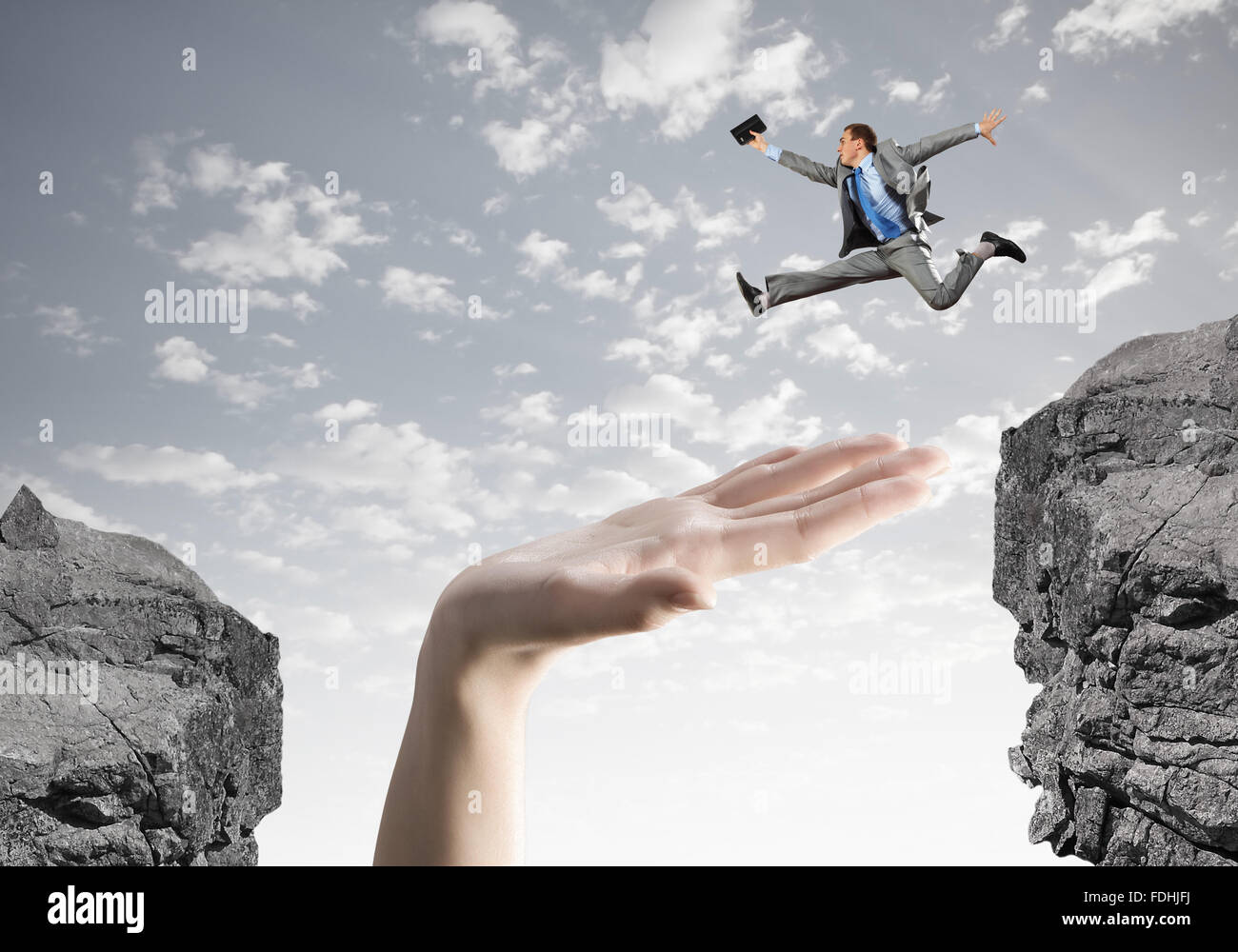 Young successful businessman jumping over gap. Risk and challenge ...
