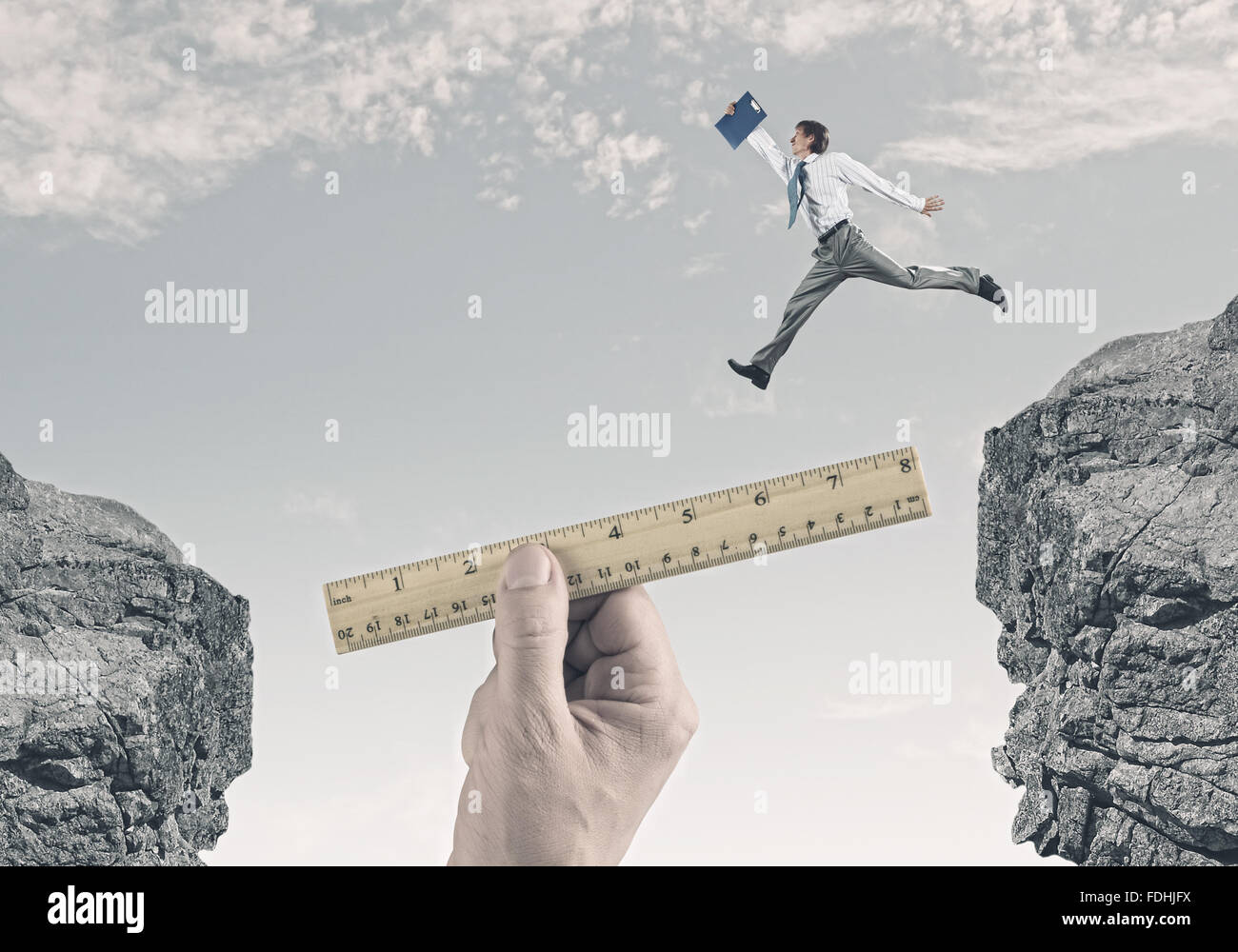 Young successful businessman jumping over gap. Risk and challenge ...