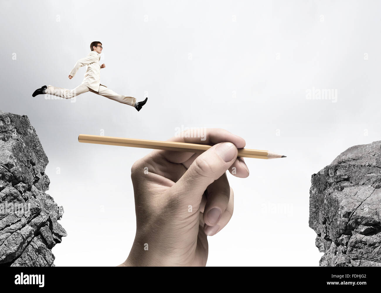 Young successful businessman jumping over gap. Risk and challenge ...