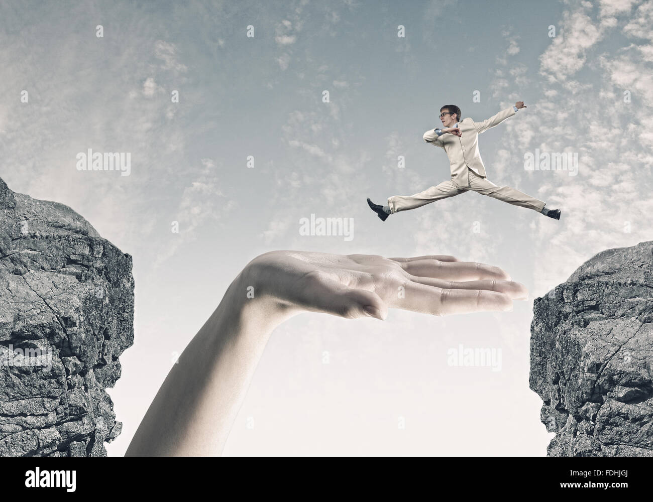 Young successful businessman jumping over gap. Risk and challenge ...