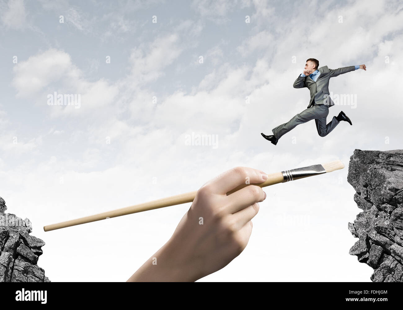 Young successful businessman jumping over gap. Risk and challenge ...