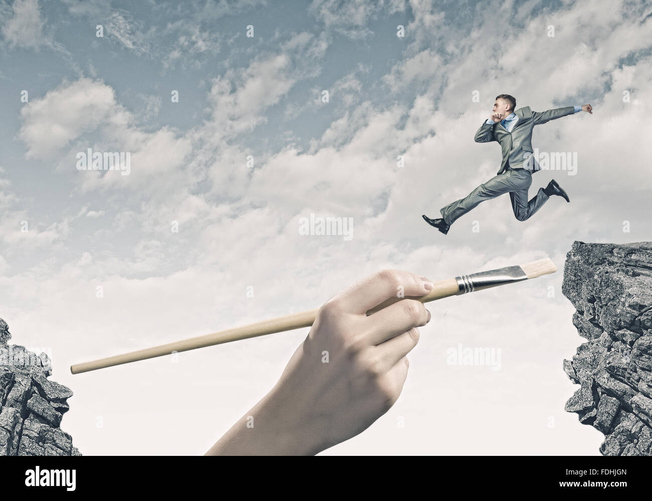 Young successful businessman jumping over gap. Risk and challenge ...