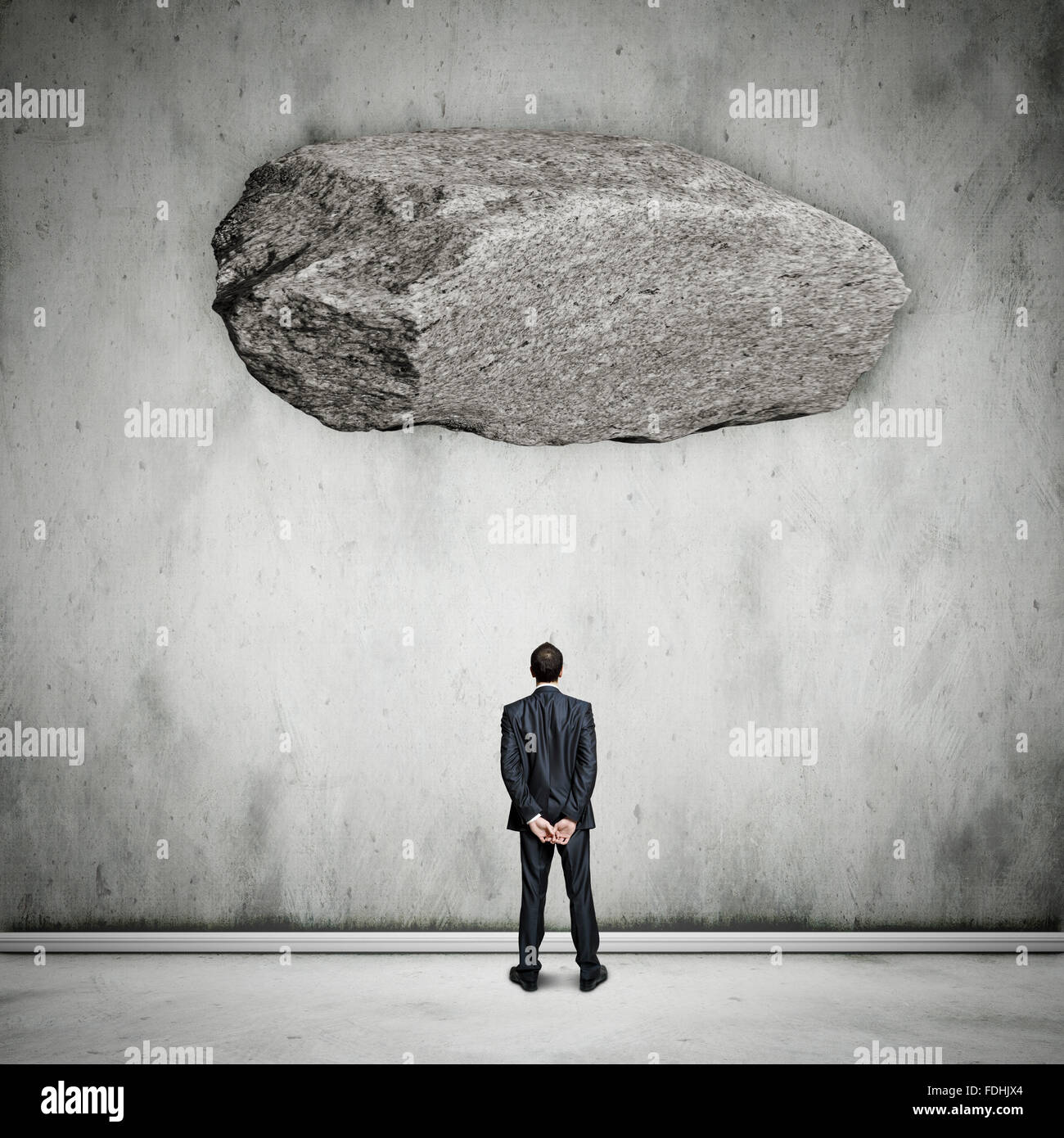 Rear view of confident businessman with huge stone above Stock Photo ...