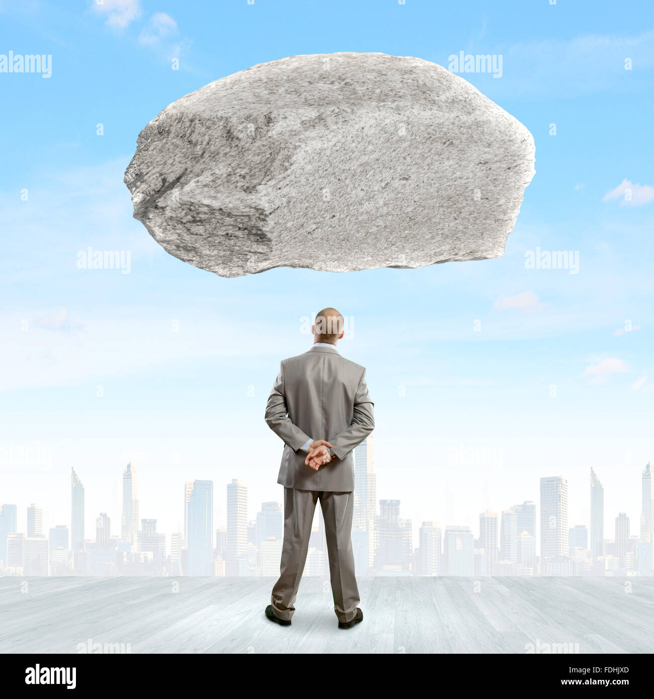 Rear view of confident businessman with huge stone above Stock Photo ...