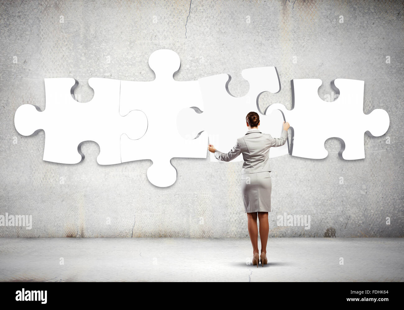 Rear view of businesswoman connecting white puzzle Stock Photo - Alamy