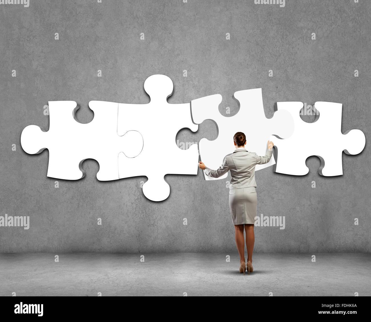 Rear view of businesswoman connecting white puzzle Stock Photo - Alamy