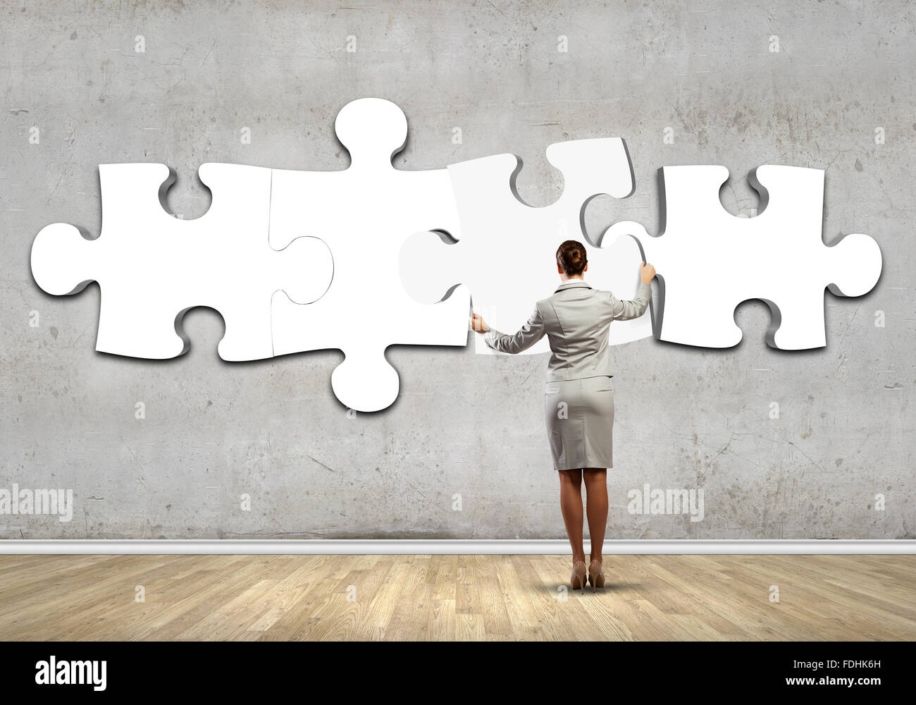 Rear view of businesswoman connecting white puzzle Stock Photo - Alamy