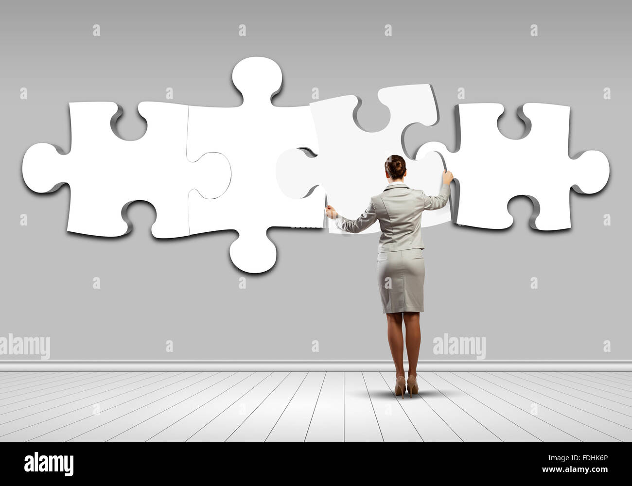 Rear view of businesswoman connecting white puzzle Stock Photo - Alamy