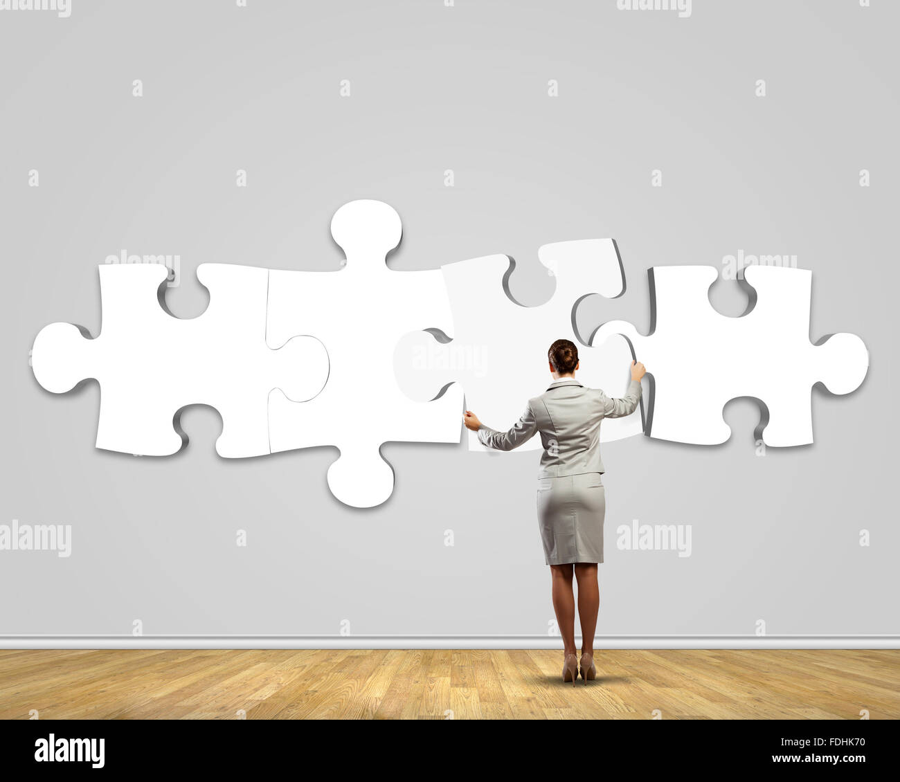 Rear view of businesswoman connecting white puzzle Stock Photo - Alamy