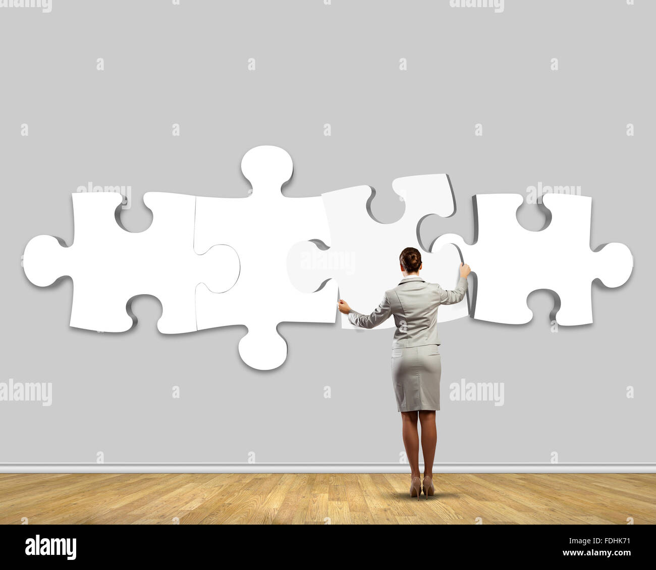Rear view of businesswoman connecting white puzzle Stock Photo - Alamy