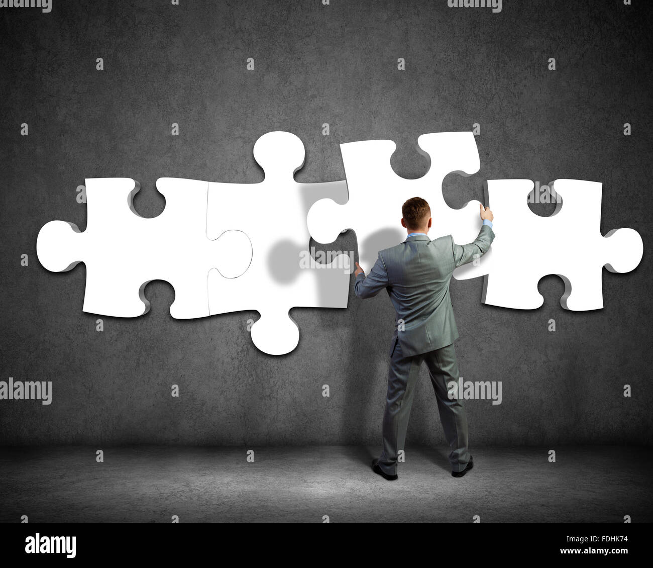 Rear view of businessman connecting white puzzle Stock Photo - Alamy