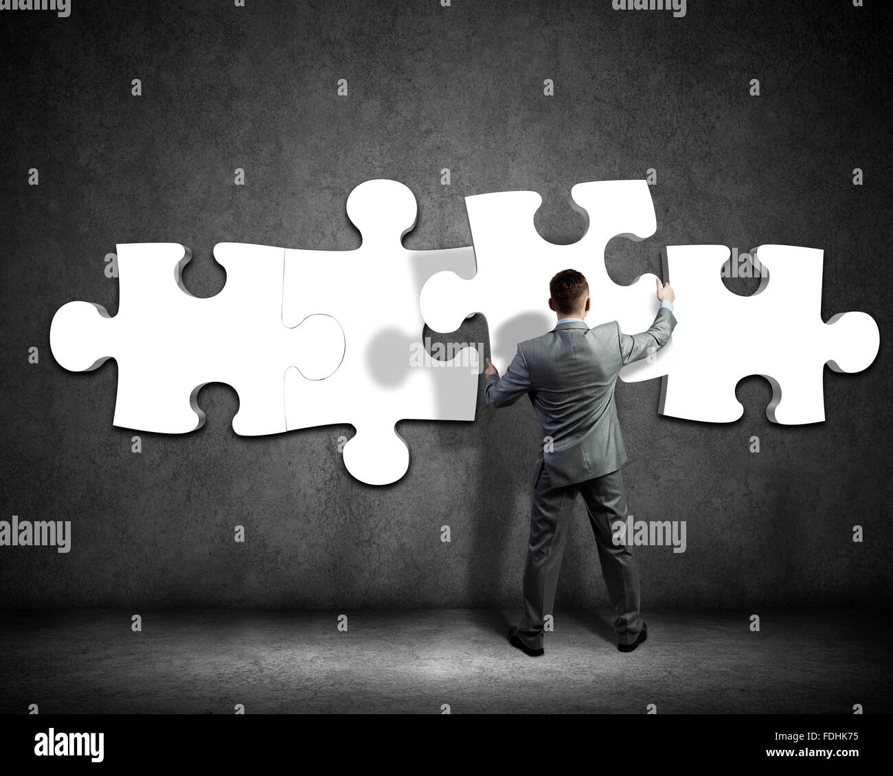 Rear view of businessman connecting white puzzle Stock Photo - Alamy