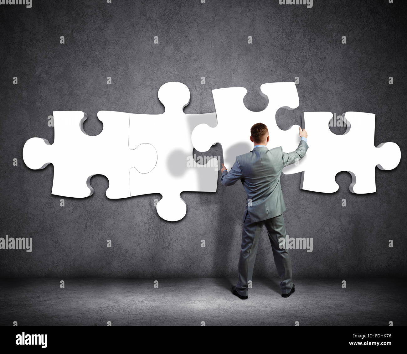 Rear view of businessman connecting white puzzle Stock Photo - Alamy