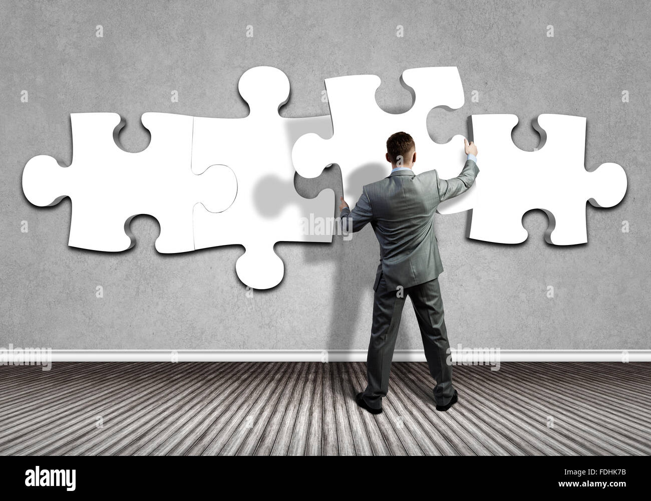 Rear view of businessman connecting white puzzle Stock Photo - Alamy