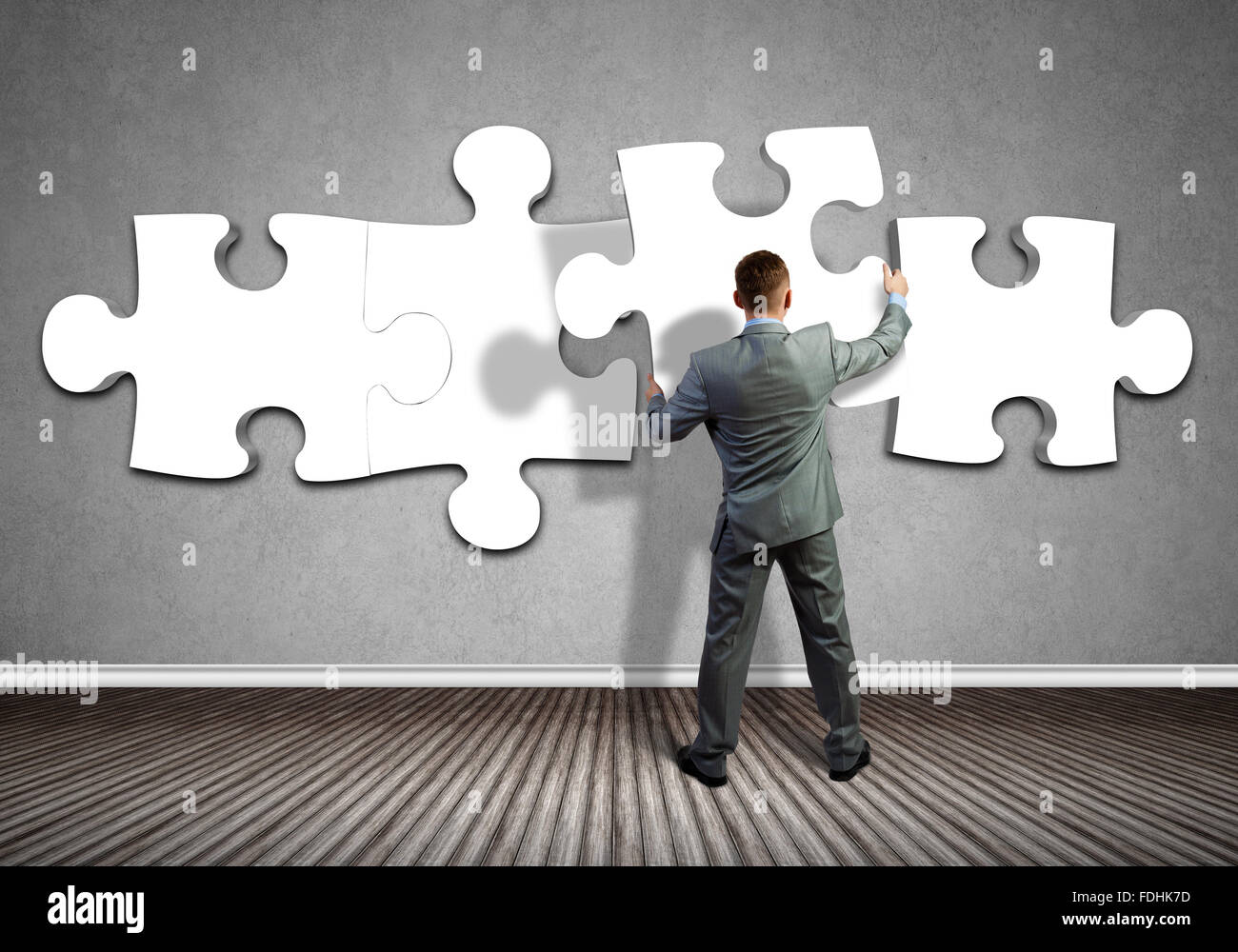 Rear view of businessman connecting white puzzle Stock Photo - Alamy