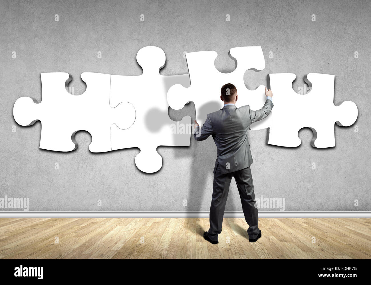 Rear view of businessman connecting white puzzle Stock Photo - Alamy