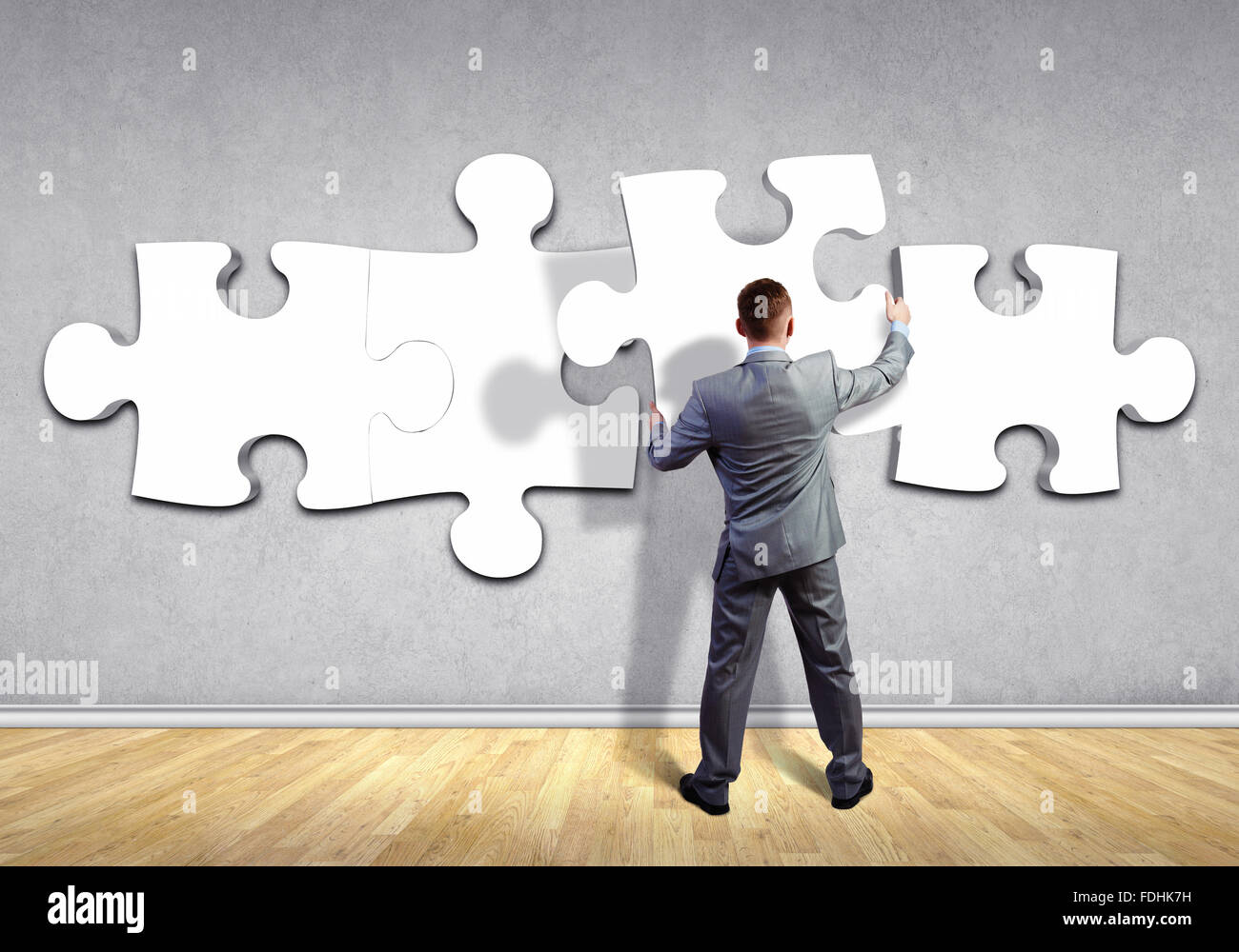 Rear view of businessman connecting white puzzle Stock Photo - Alamy