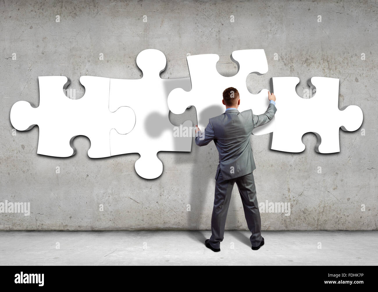 Rear view of businessman connecting white puzzle Stock Photo - Alamy