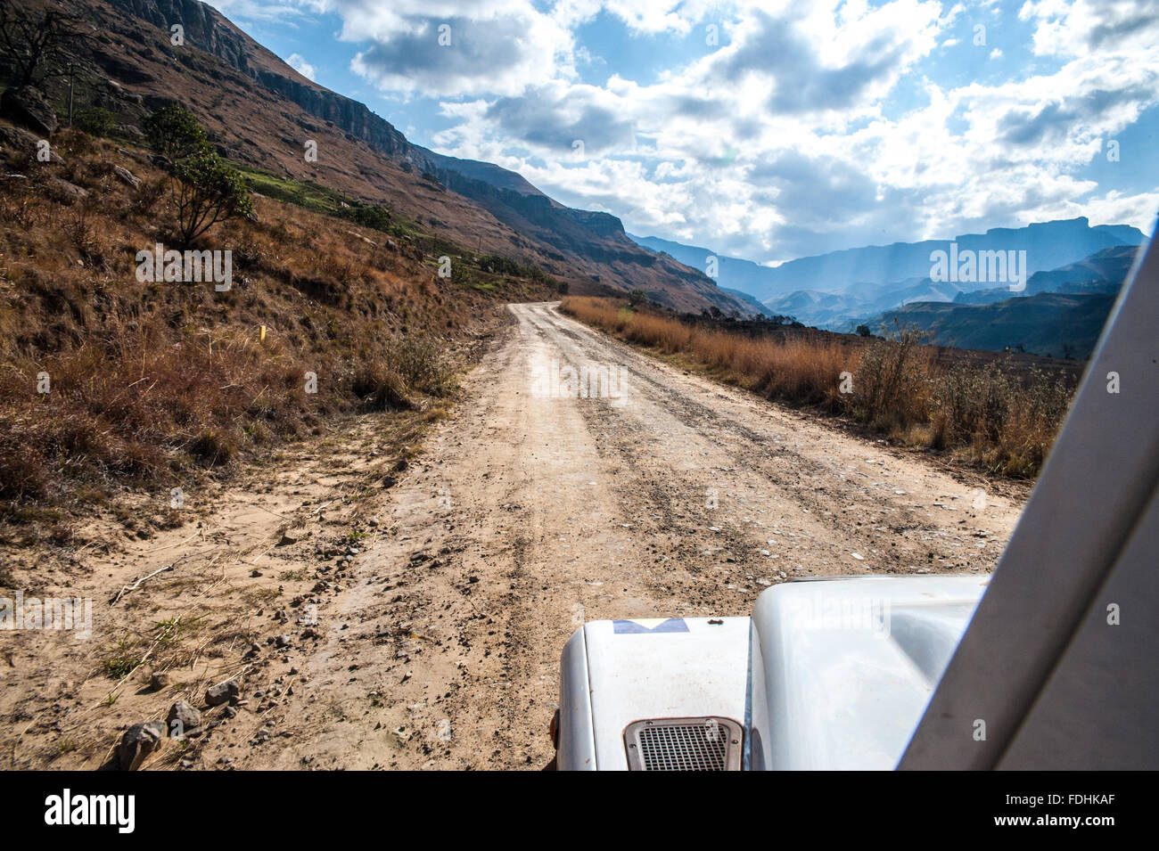 Land Rover Defender driving down a dirt road in Sani pass between South ...