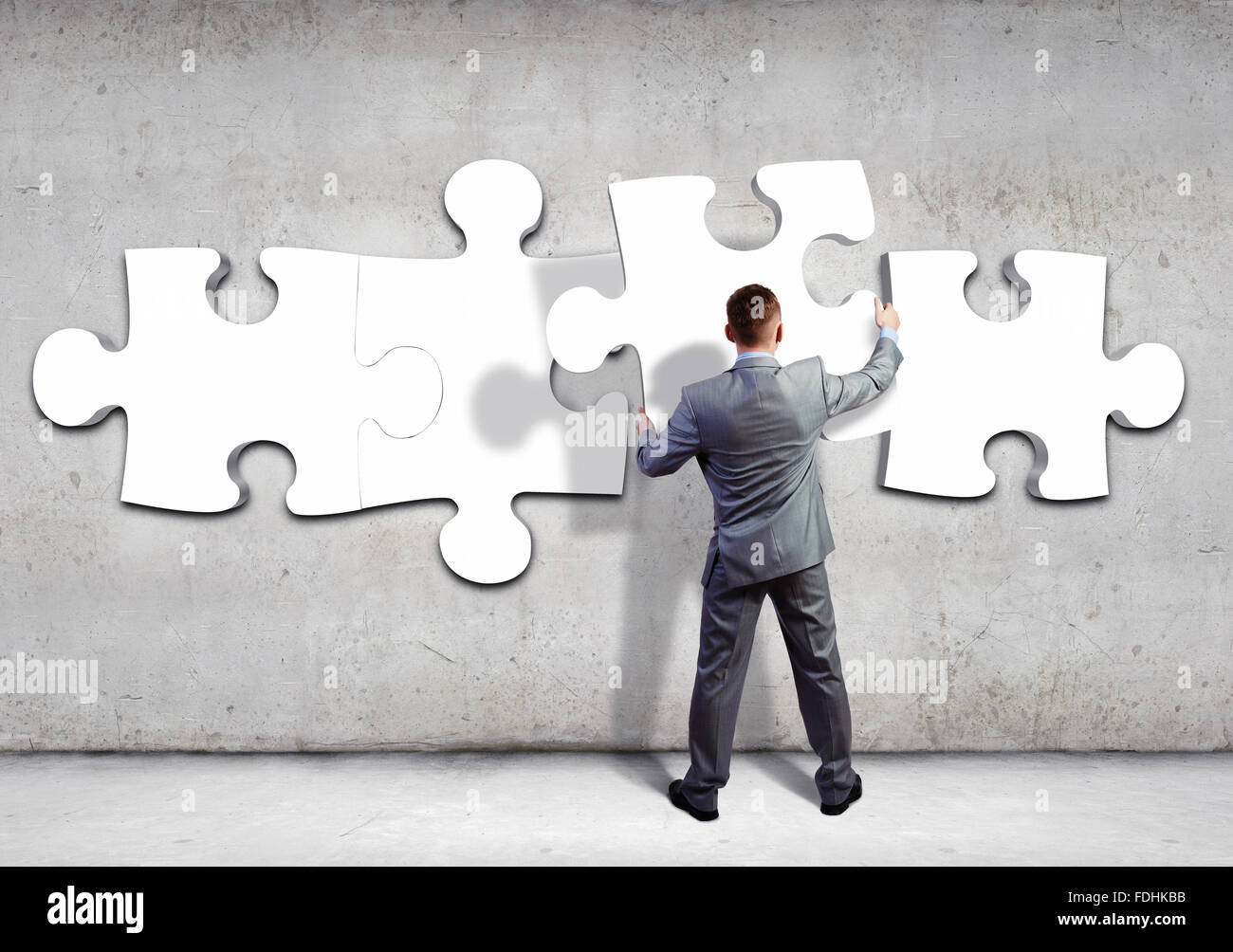 Rear view of businessman connecting white puzzle Stock Photo - Alamy