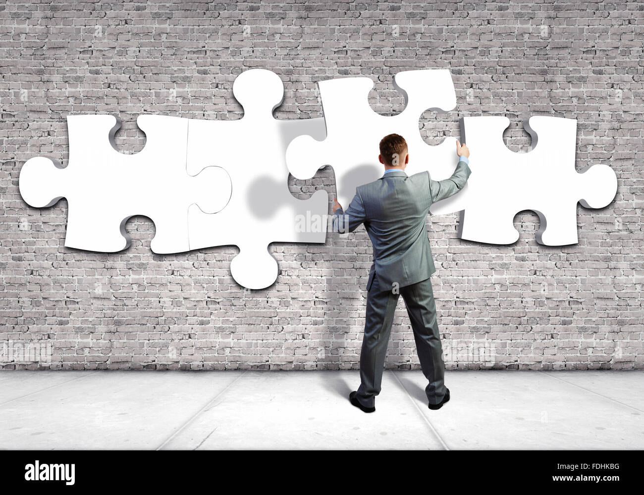 Rear view of businessman connecting white puzzle Stock Photo - Alamy