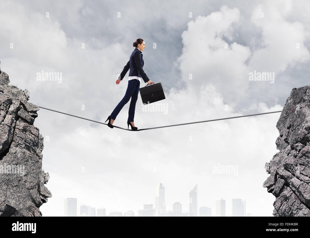 Young confident businesswoman walking on rope above gap Stock Photo - Alamy