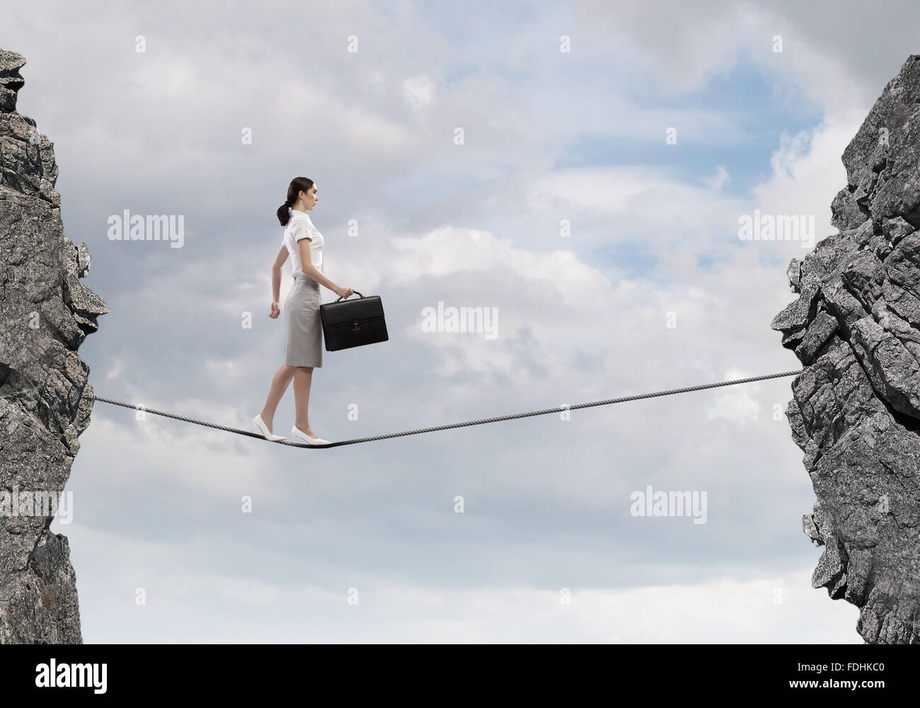 Young confident businesswoman walking on rope above gap Stock Photo - Alamy