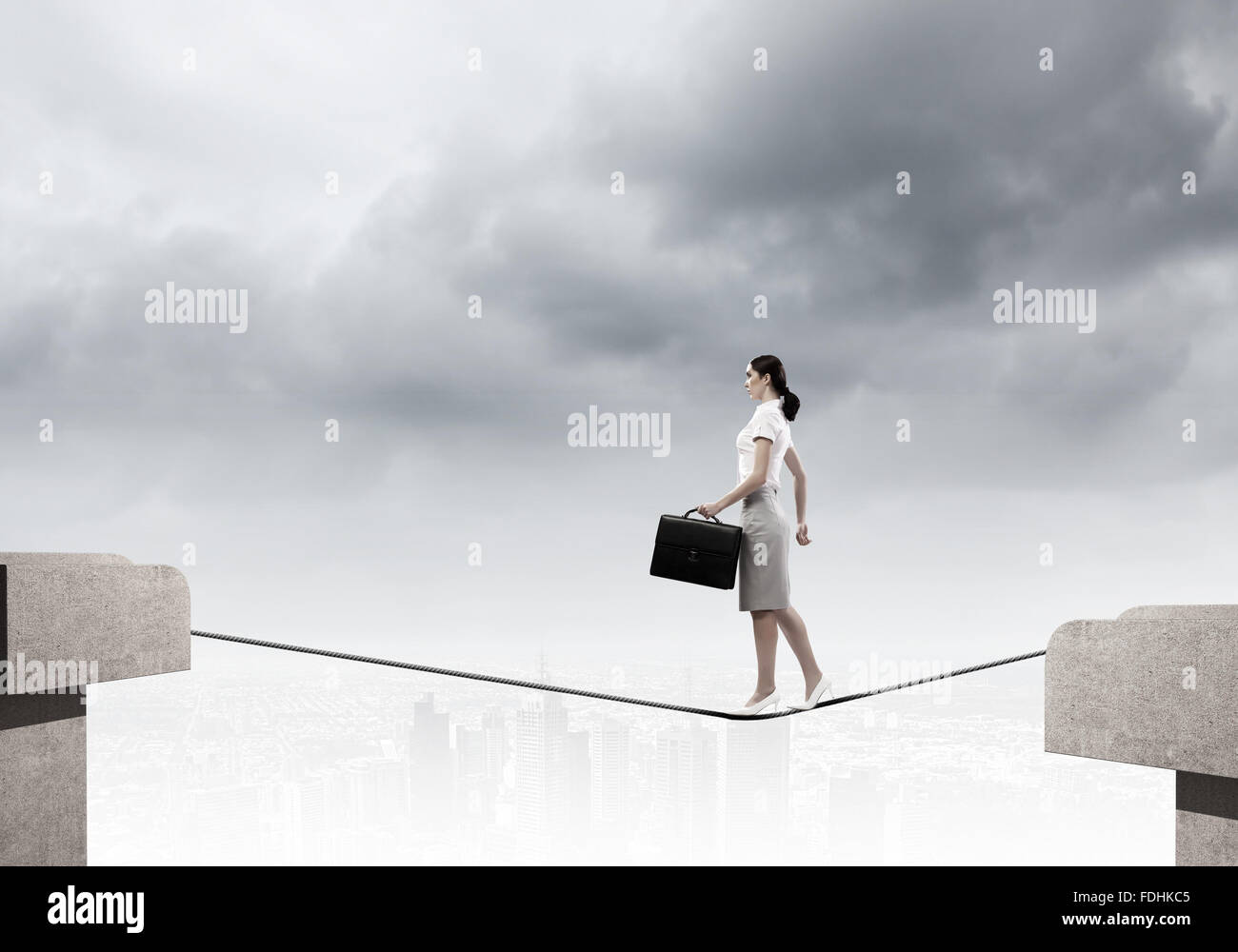 Young confident businesswoman walking on rope above gap Stock Photo - Alamy