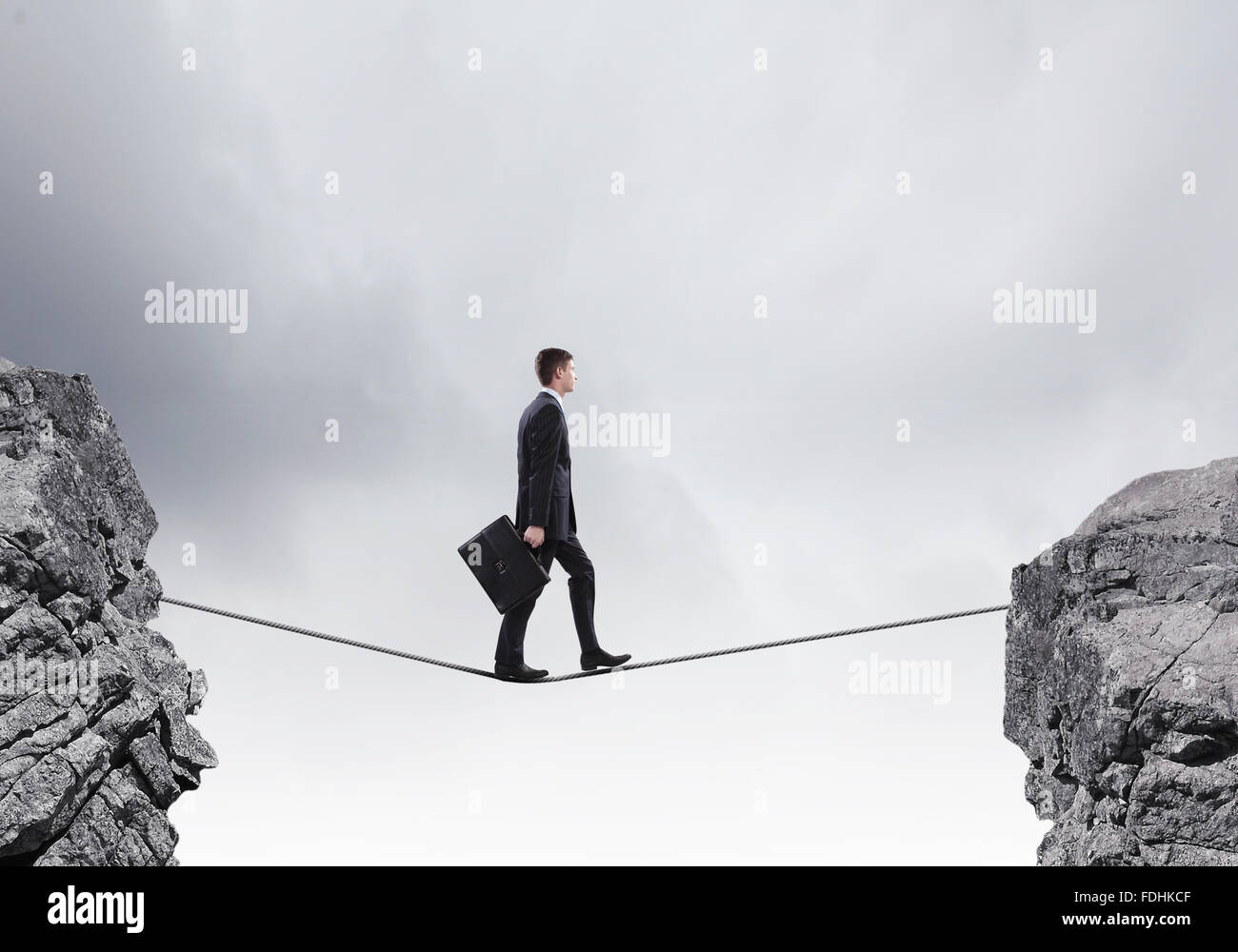 Conceptual image of businessman walking on rope above gap Stock Photo ...