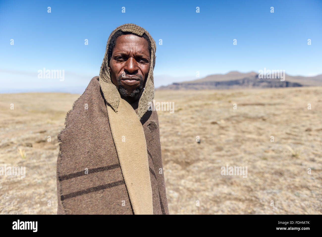 Portrait of a local shepherd wrapped in a blanket in the mountains of ...