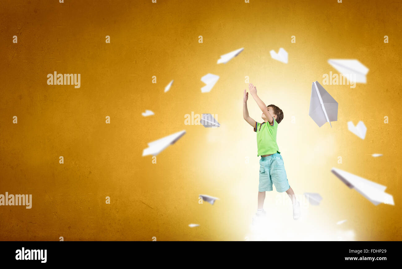 Little cute boy catching paper airplane on colorful background Stock ...