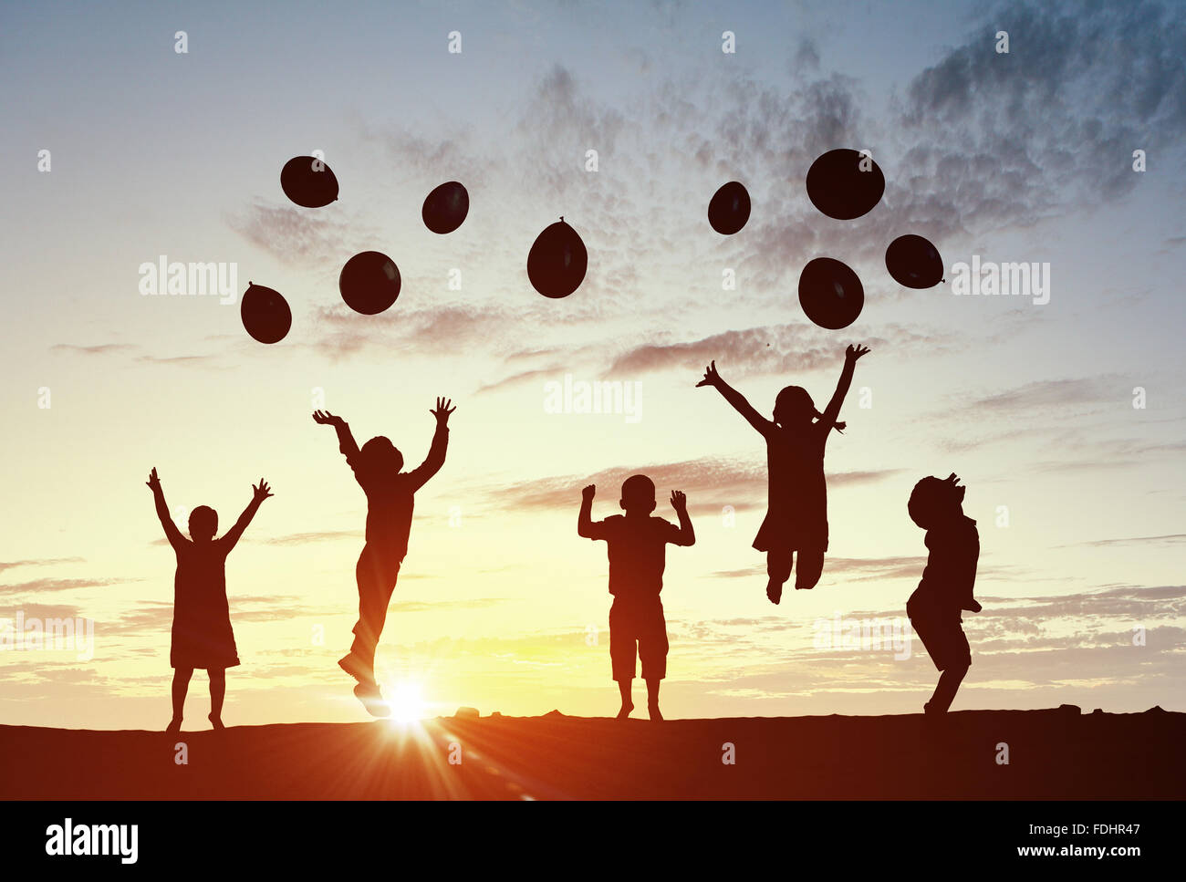 Silhouettes of group of children jumping on sunset background Stock ...