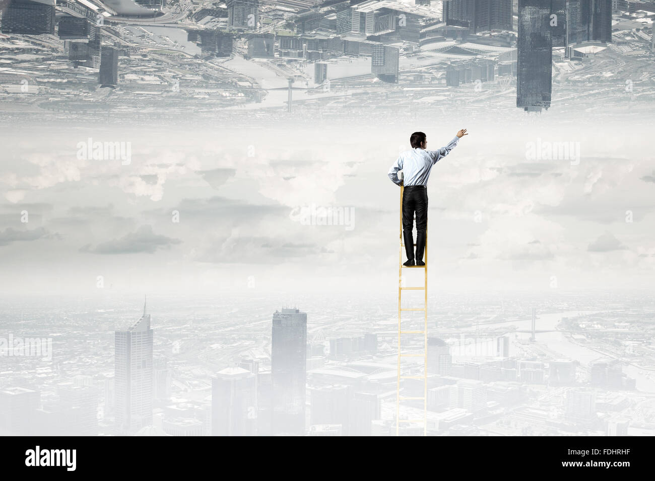 Businessman standing on ladder between two urban realities Stock Photo ...