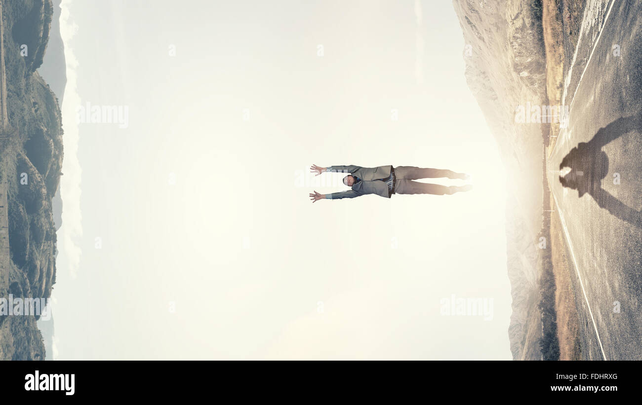 Young businessman making jump between two realities Stock Photo - Alamy