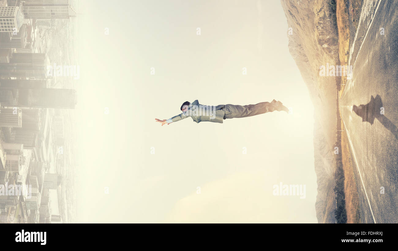 Young businessman making jump between two realities Stock Photo - Alamy