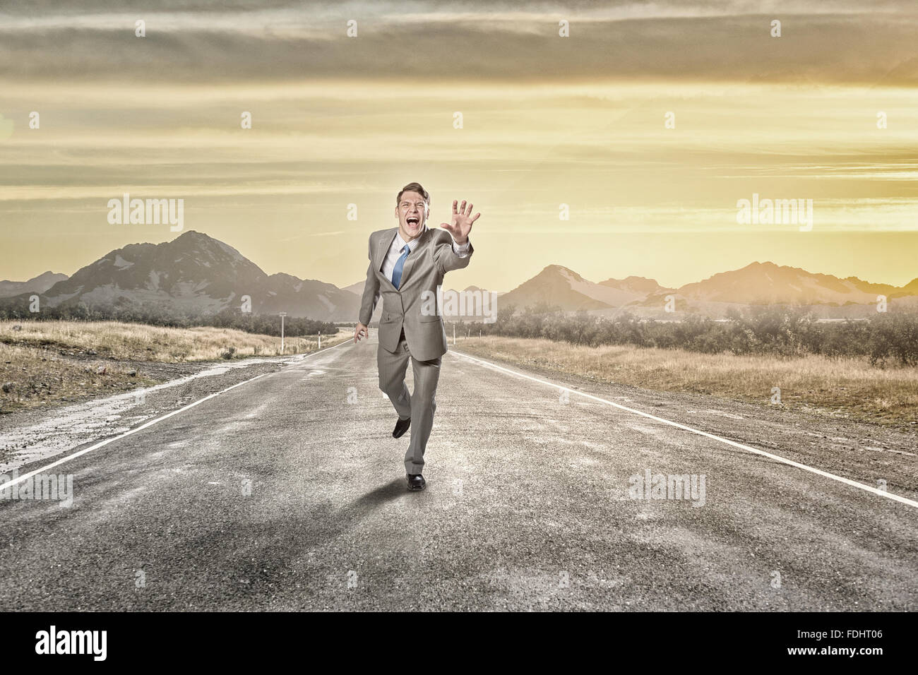 Young screaming businessman running on asphalt road Stock Photo - Alamy