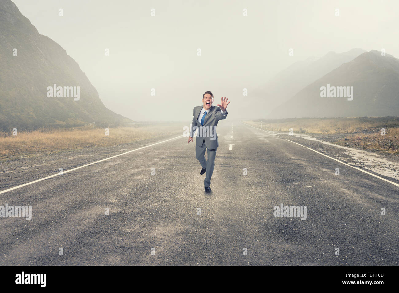 Young screaming businessman running on asphalt road hi-res stock ...
