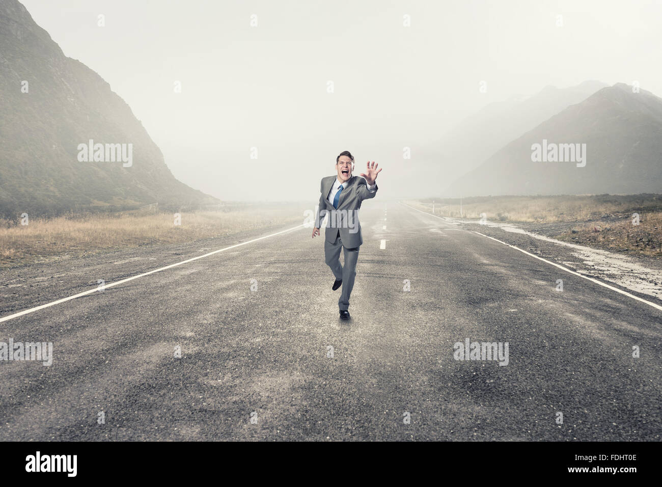 Young screaming businessman running on asphalt road Stock Photo - Alamy