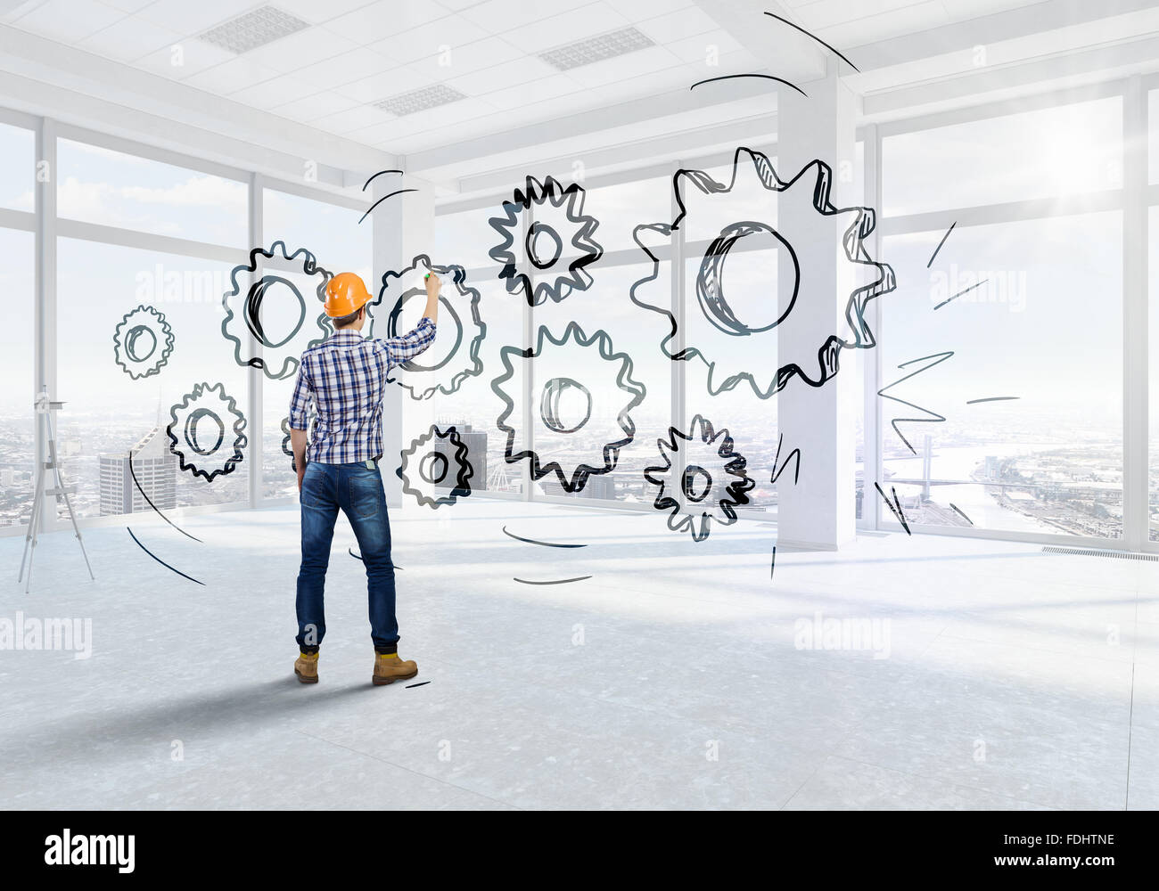 Engineer in helmet in modern office drawing gears Stock Photo - Alamy