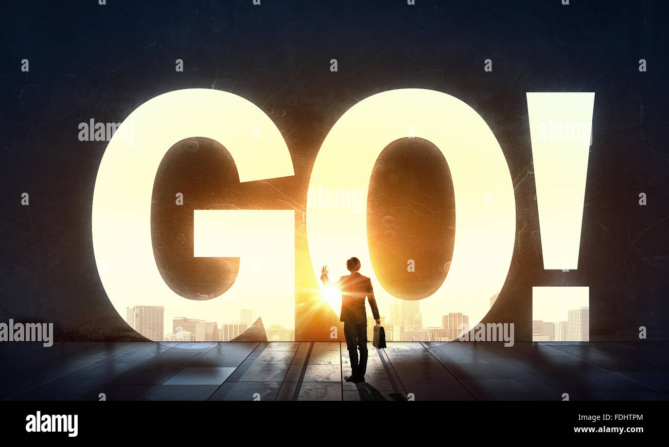 Back view of businessman standing in light of GO word Stock Photo - Alamy