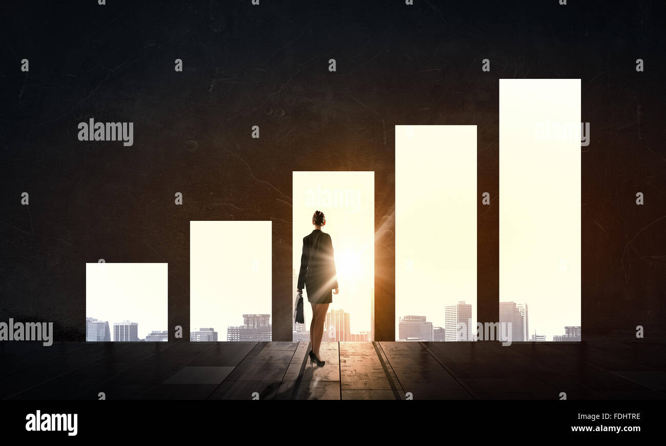 Back view of businesswoman standing in light of profit concept Stock ...